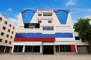 Um edifício de vários andares com uma placa chamativa que diz 'Collection' e o logotipo da 'YOYO Serviced'.