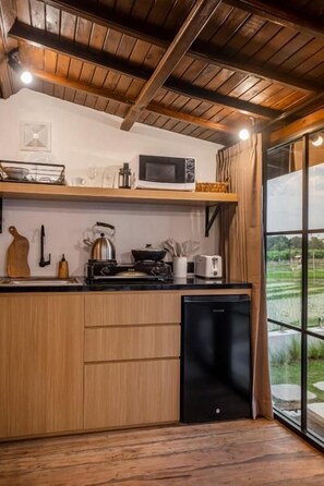 Cozinha com armários de madeira, micro-ondas, torradeira e máquina de lavar louça.