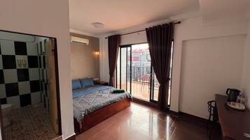 Quarto com cama, banheiro com piso xadrez e varanda com vista.