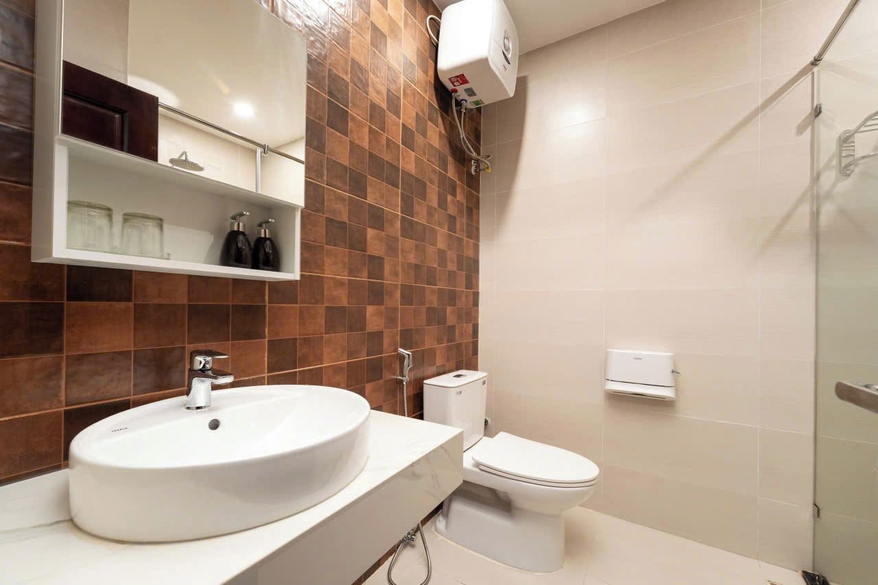 Casa de banho com lavatório branco, sanita e zona de duche.