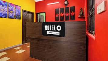 Balcão de recepção de hotel com uma placa indicando que o serviço é realizado pela OYO.