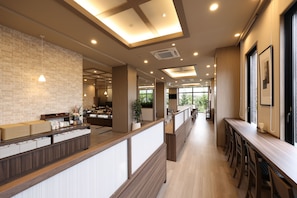 Interior moderno com balcão extenso, área de estar e parede de tijolos.