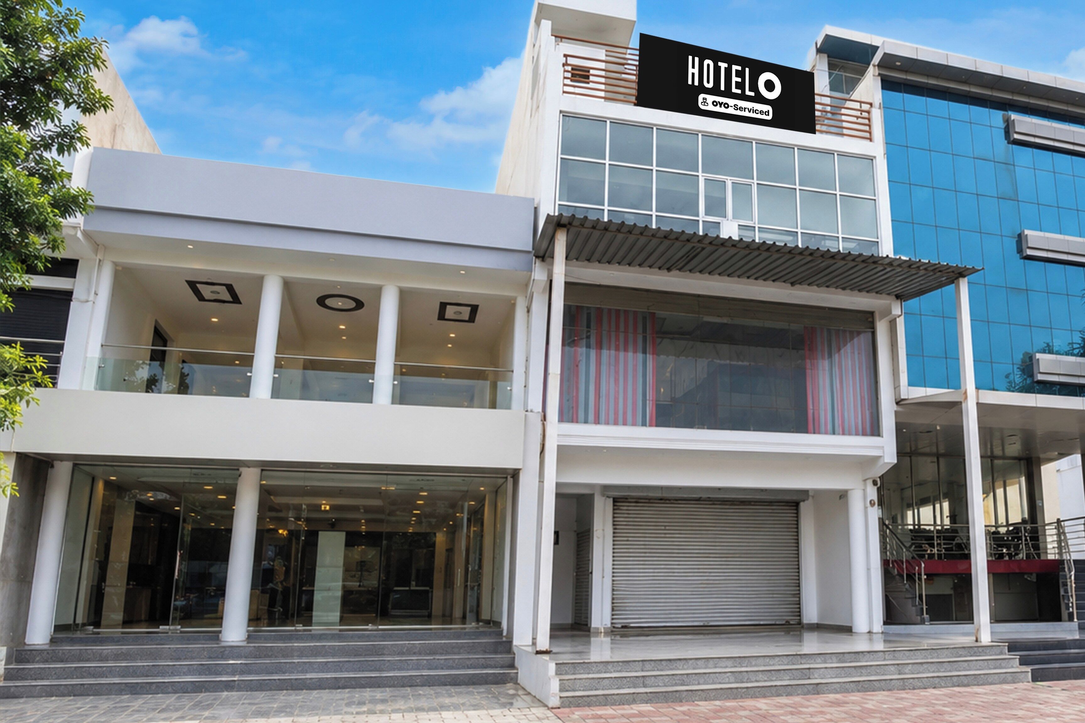 Hotel com fachada moderna, entrada visível e placa indicando que oferece serviços acima da média.