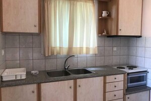 Uma cozinha com pia, fogão e armários.