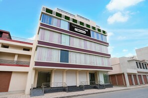 Edifício de vários andares com placa indicando ser um apartamento por temporada.