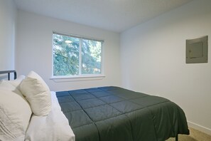 Quarto com cama, janela e tomadas na parede.