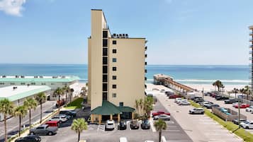 Hotel com vários andares, estacionamento, vista para a praia e calçadão.