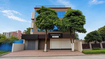 Uma casa geminada moderna com uma placa preta que diz 'TOWNHOUSE' e 'OYO-Serviced'.