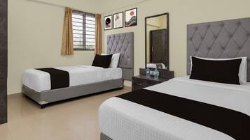 Quarto de hotel com duas camas, janela com cortinas, mesa de cabeceira com espelho e uma obra de arte na parede.