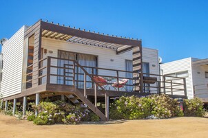 Casa móvel com varanda, área de estar ao ar livre e um jardim.