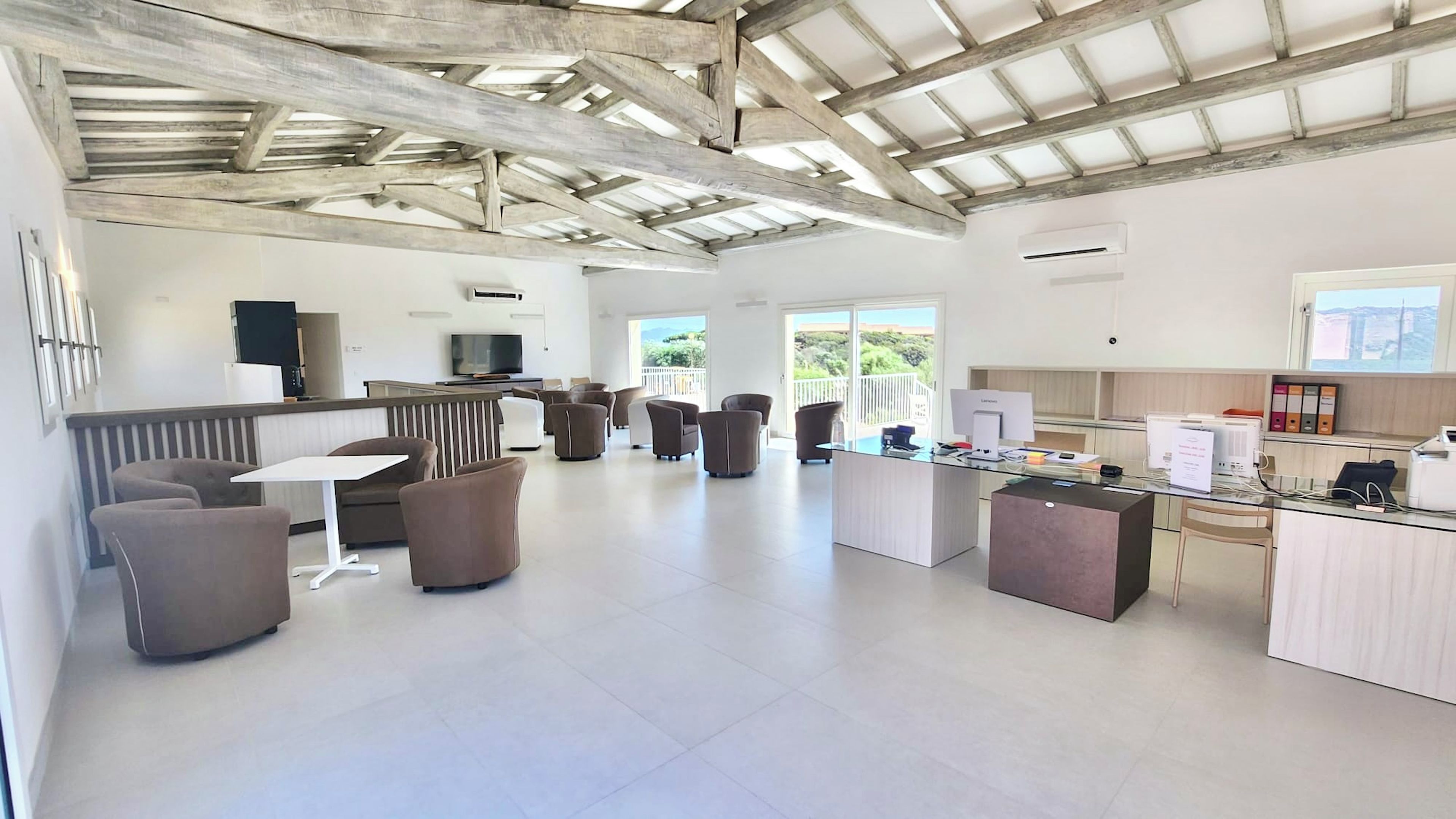 Ampla sala de estar com pé direito alto, cozinha equipada com eletrodomésticos modernos e área de estar com sofás e mesa de centro.