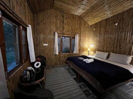 Quarto com cama, escrivaninha, janela e abajur.