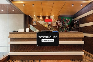 Uma área de recepção com uma placa que diz 'TOWNHOUSE' e 'YOY-Serviced'.