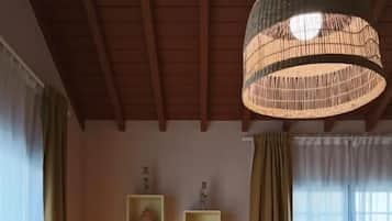 Sala de estar com sofá, poltrona, luminária de chão e pendente.