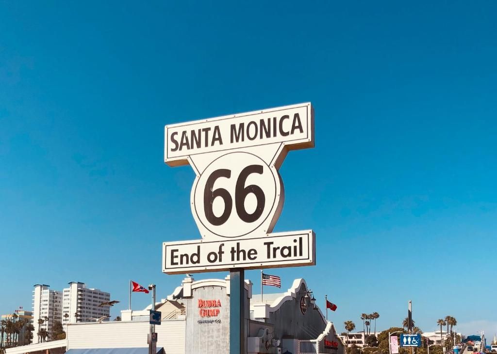 Placa de Santa Monica 66, Fim da Estrada, com um céu azul claro ao fundo.