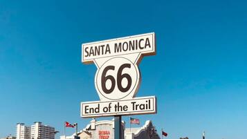 Placa de Santa Monica 66, Fim da Estrada, com um céu azul claro ao fundo.