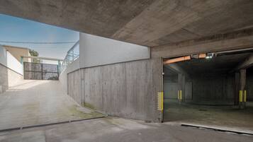 Garagem de estacionamento vazia com paredes de concreto e telhado inclinado.