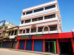 Um edifício de vários andares com uma farmácia e uma hospedaria no andar térreo.