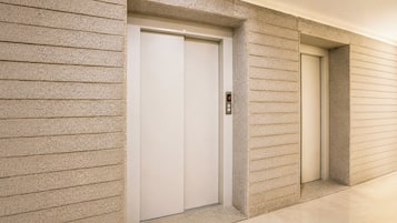Corredor com duas portas de elevador, uma delas com visor digital.
