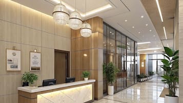 Uma área de recepção moderna com balcão de mármore, iluminação pendente e divisória de parede em vidro.