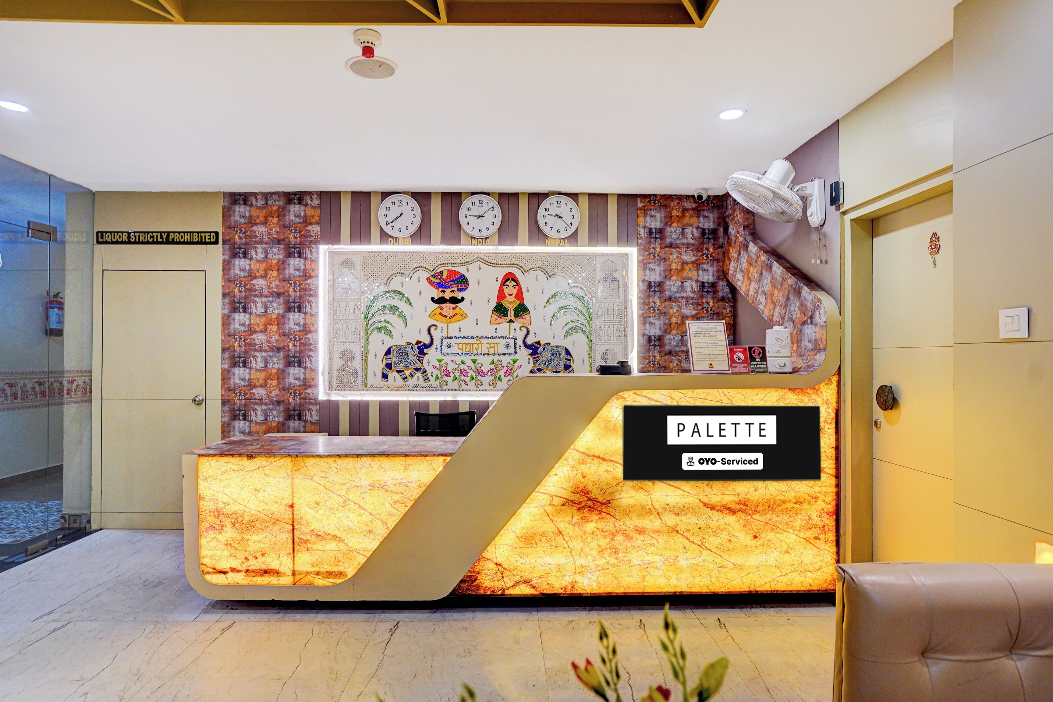 Um balcão de recepção com uma placa indicando 'PALETTE' e um relógio acima.