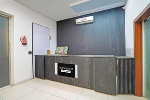 Balcão de recepção com uma placa indicando que o serviço é fornecido pela OYO.