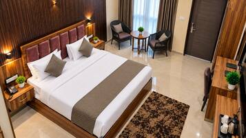 Quarto de hotel moderno com uma cama grande, uma mesa e uma cadeira.