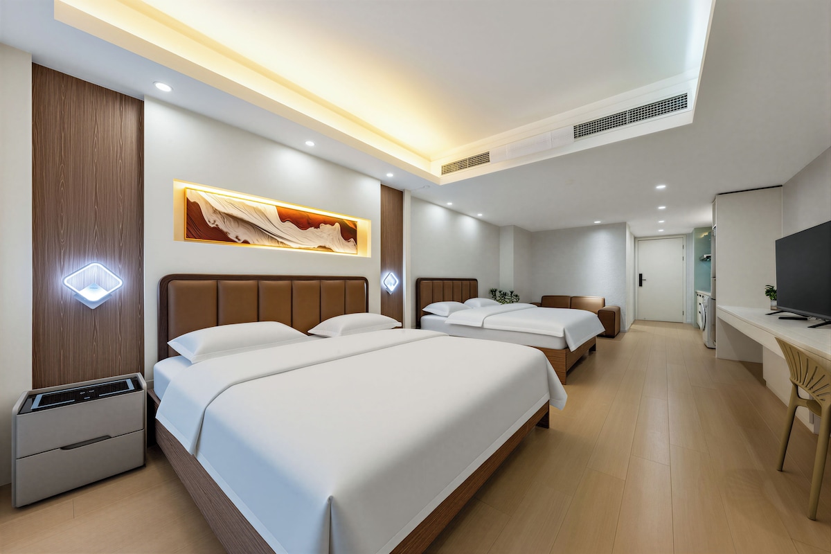 Quarto de hotel moderno com cama grande, mesas de cabeceira, televisão de tela plana e obra de arte na parede.