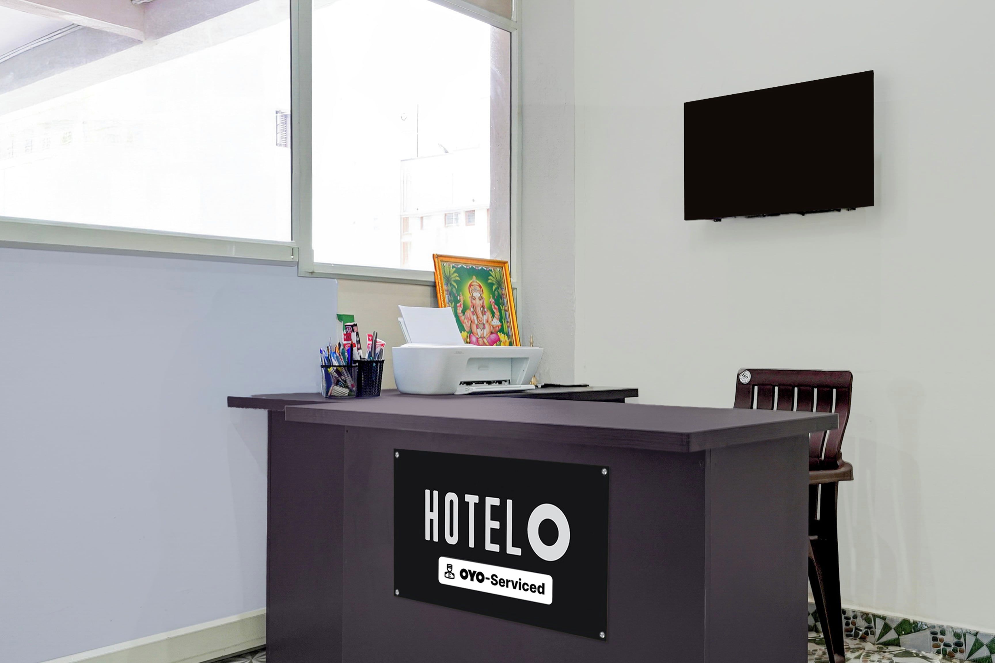 Bancada de recepção de hotel com placa indicando serviço OYO.