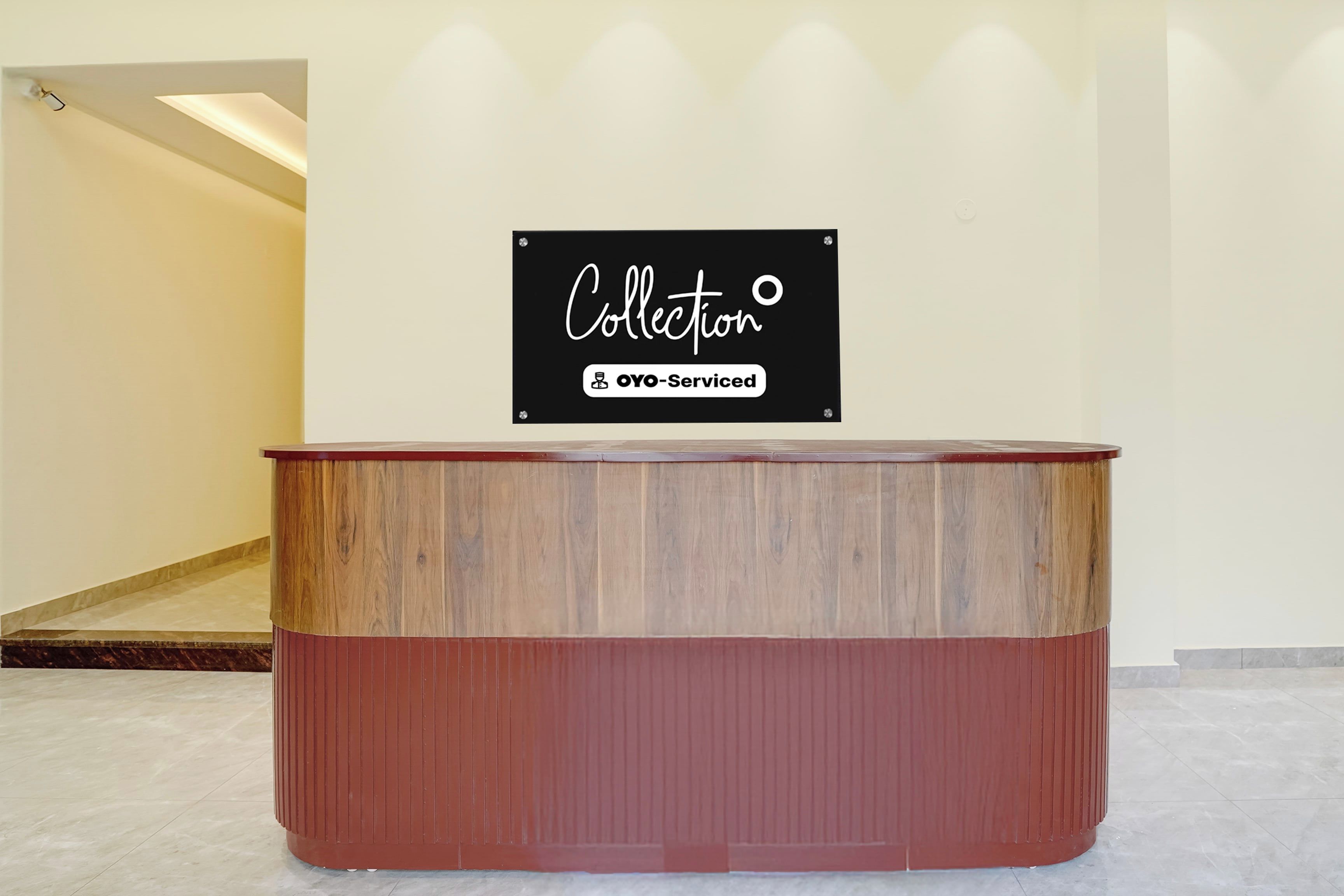 Uma mesa de recepção com uma placa acima que diz 'Collection OYO-Serviced'.