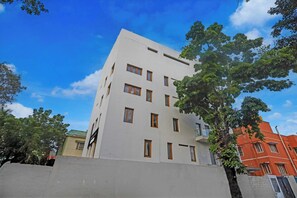 Edifício de vários andares com fachada plana e janelas regularmente espaçadas.
