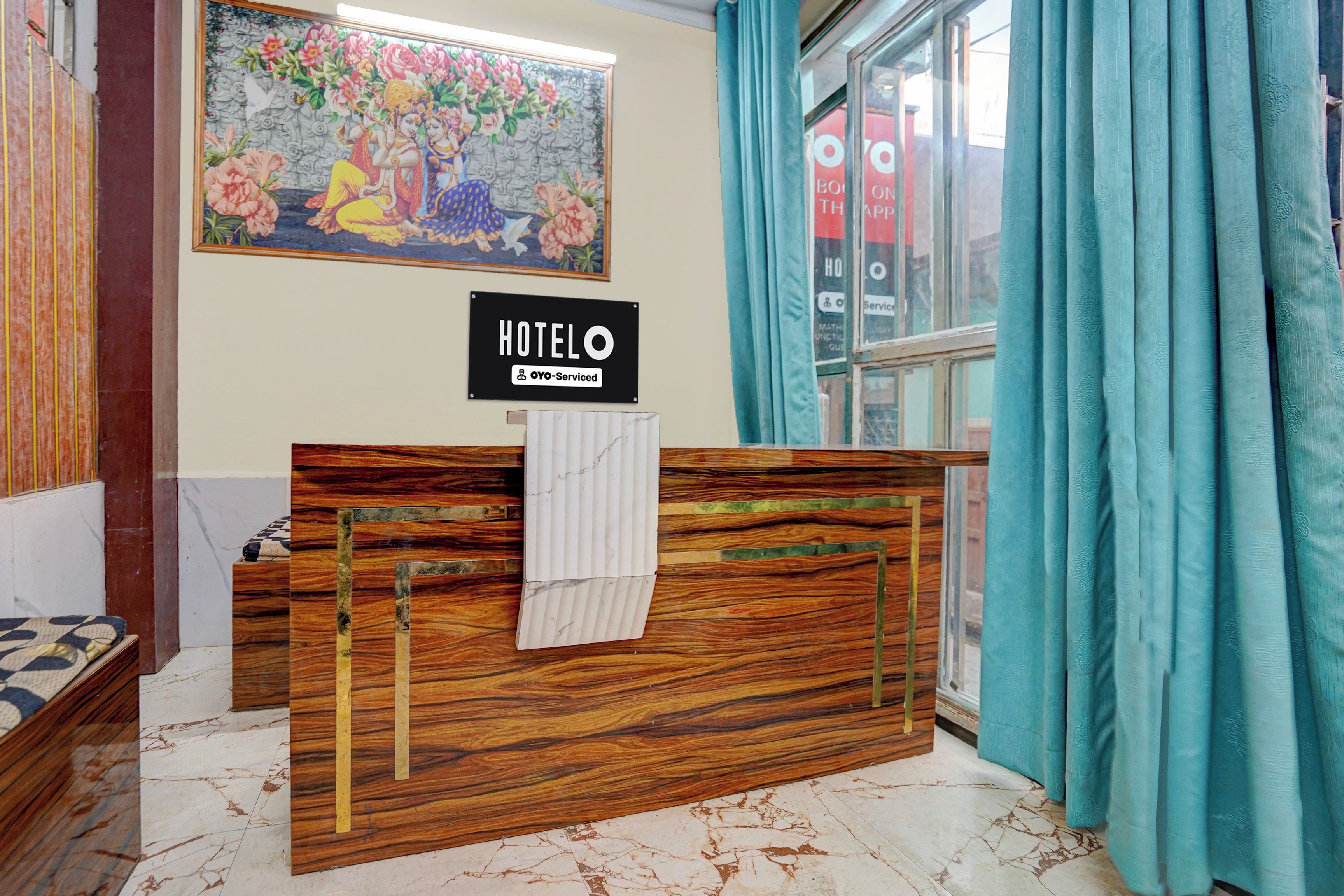 Bancada de recepção de hotel com uma placa indicando que é administrada pela OYO.