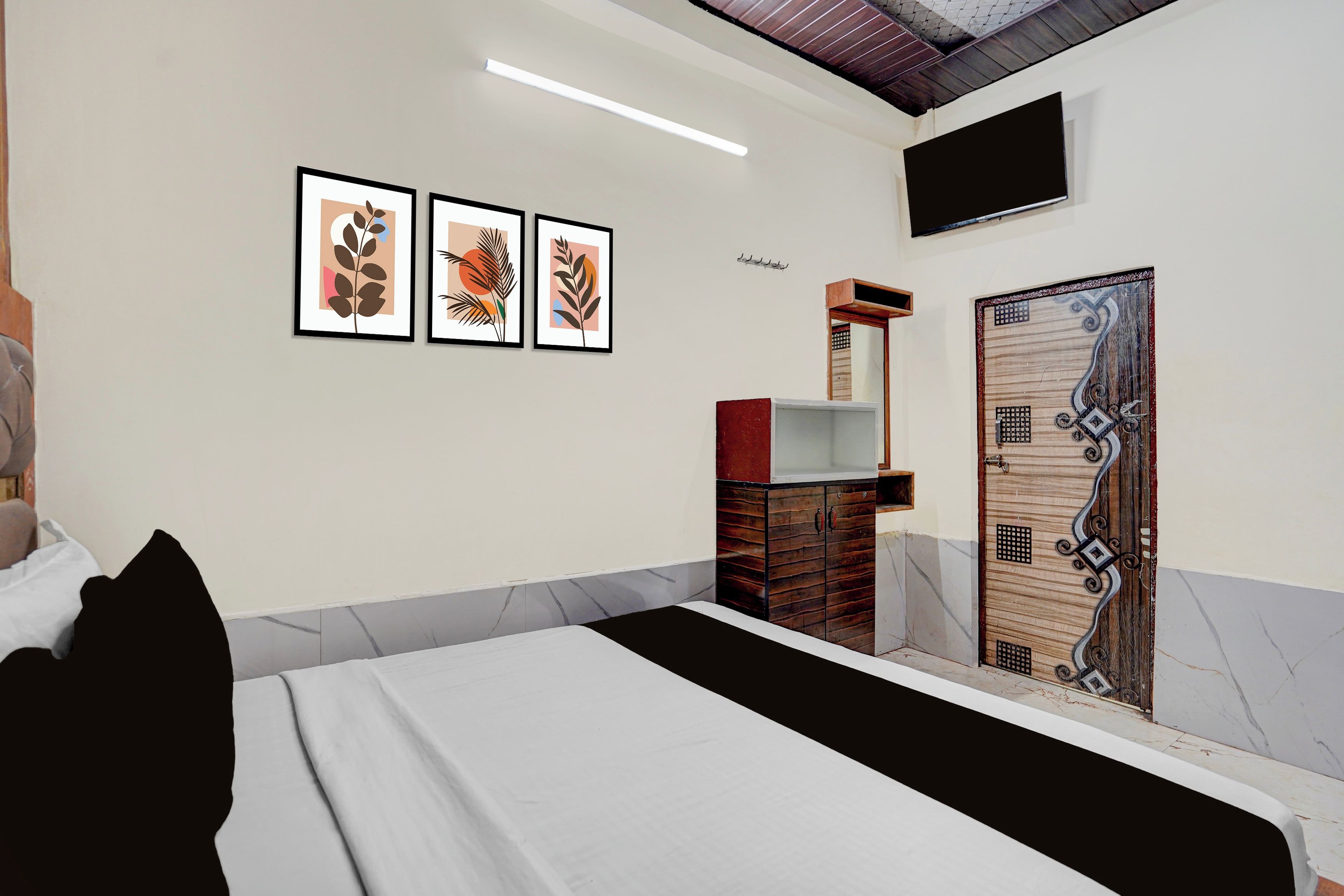 Quarto com cama, penteadeira, espelho e três quadros na parede.