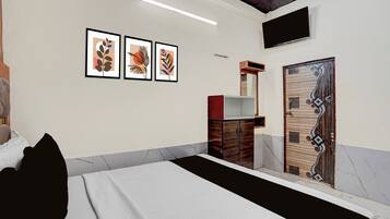 Quarto com cama, penteadeira, espelho e três quadros na parede.