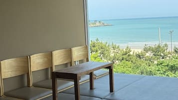 Quarto com um banco e vista para o mar.