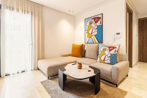 Uma sala de estar moderna com um sofá, uma mesa de centro e obras de arte na parede.