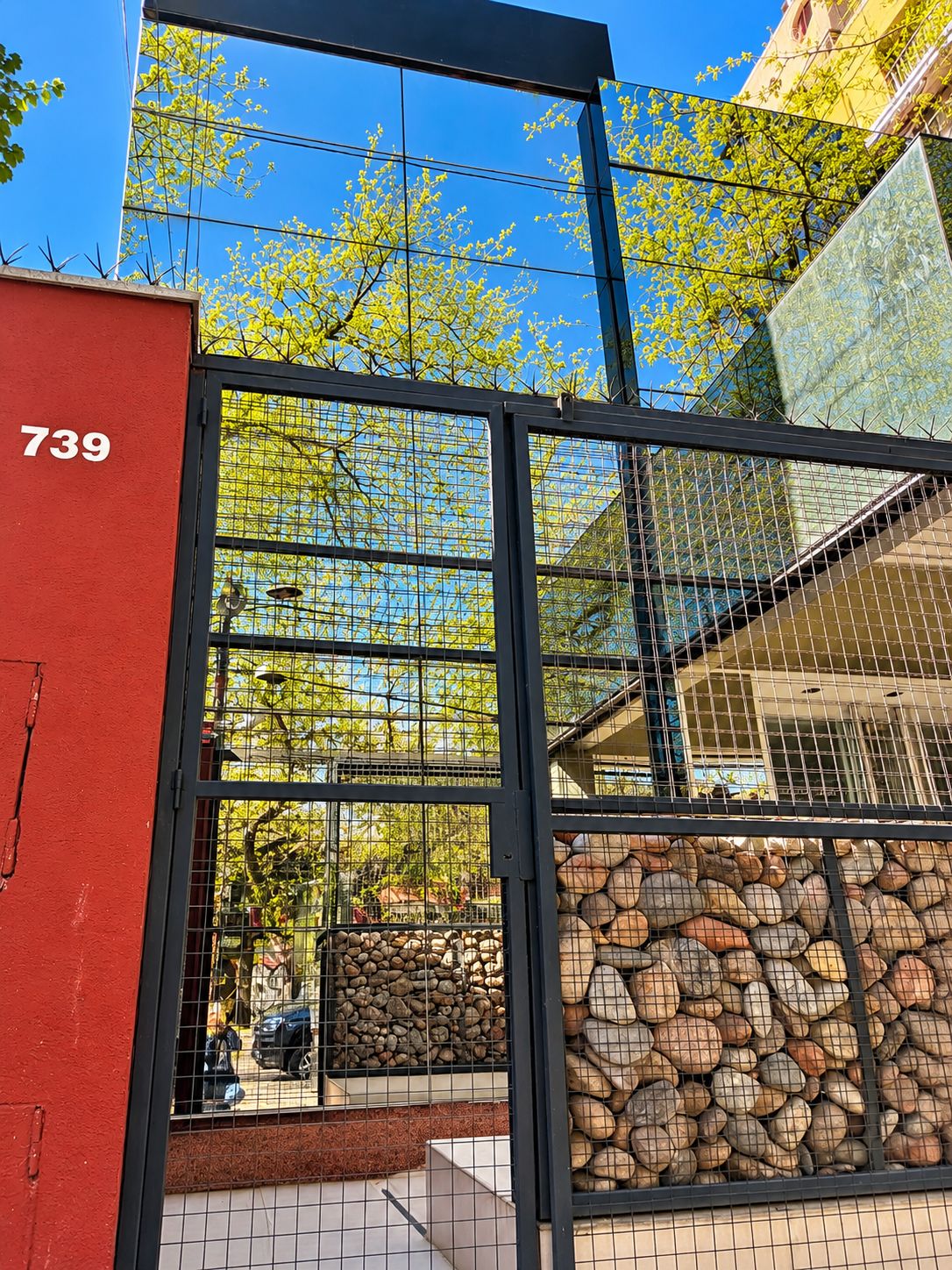 Um edifício com fachada vermelha e o número '739'.