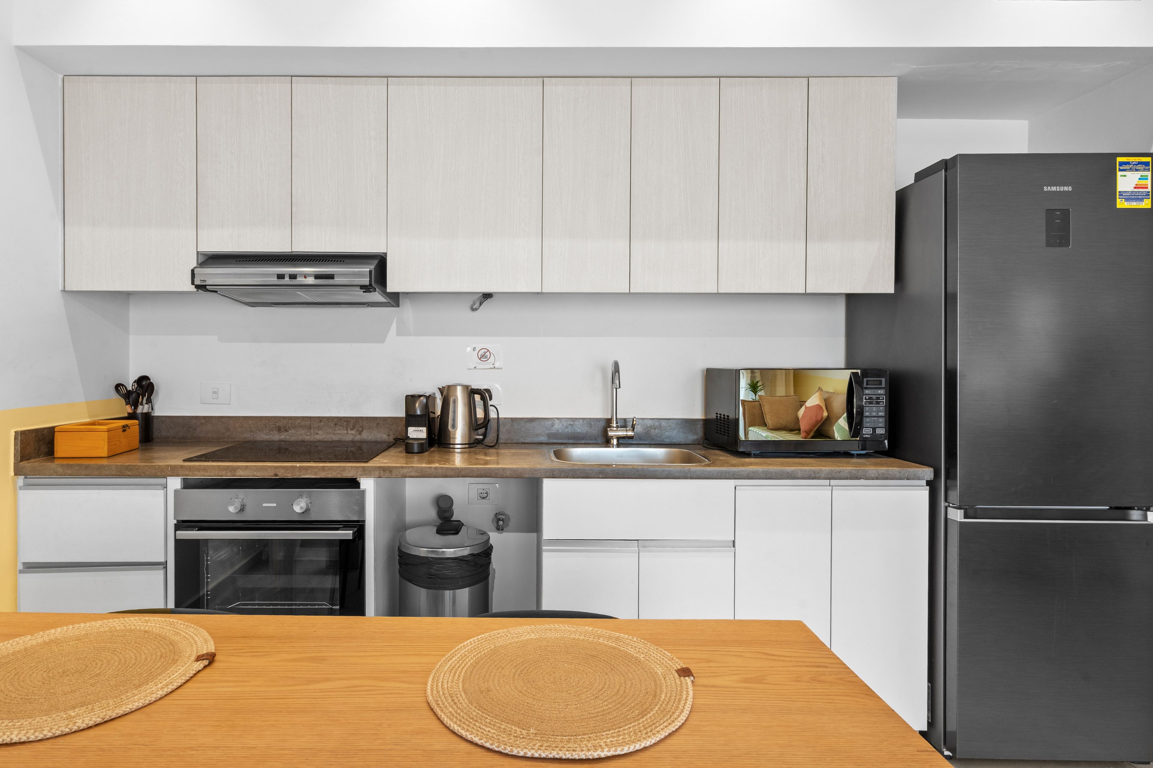 Uma cozinha moderna com eletrodomésticos de aço inoxidável, micro-ondas e forno embutido.