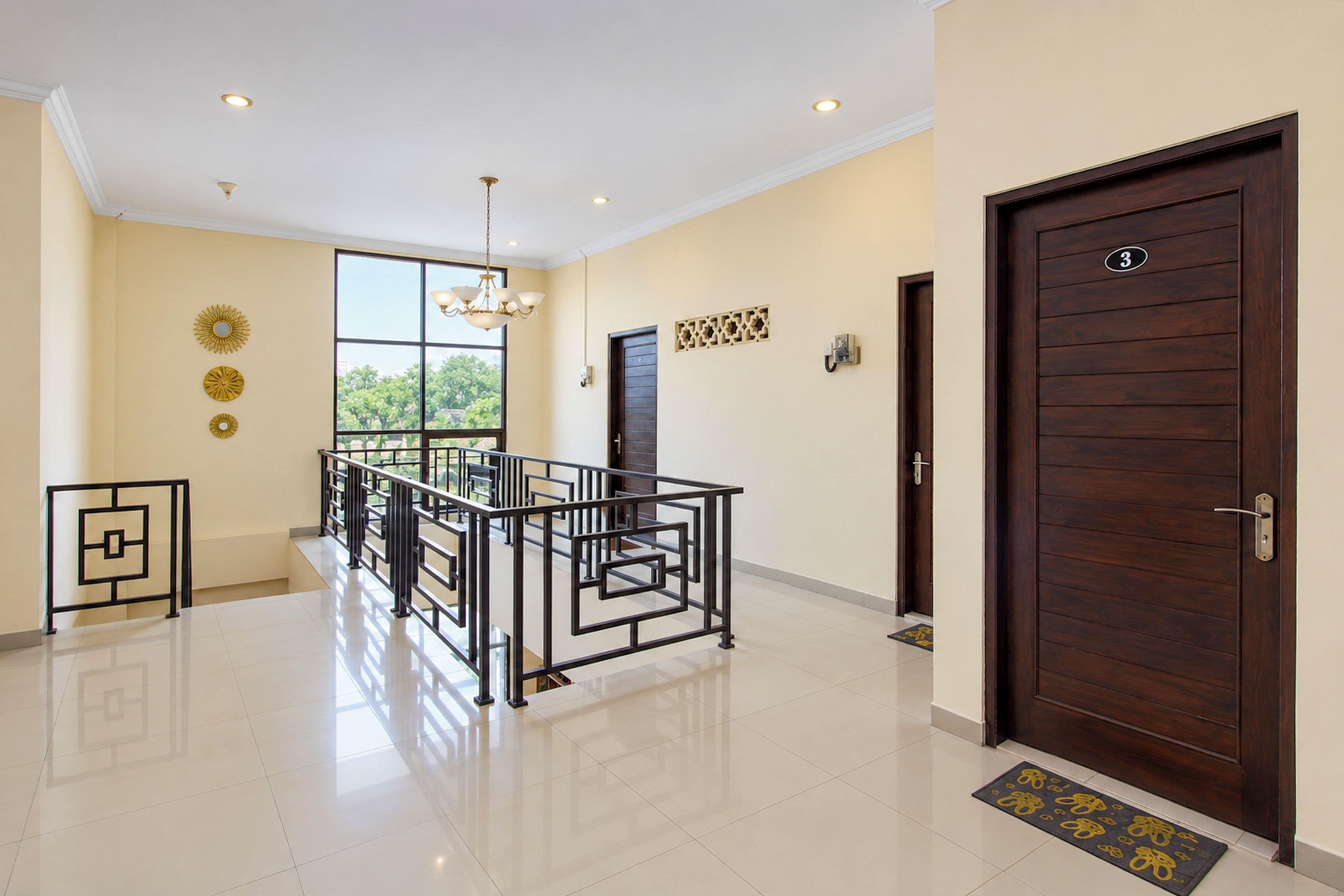 Espaçoso interior com escadaria moderna, grande janela com vista e porta de madeira escura.
