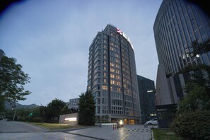 Um edifício moderno de vários andares com uma placa de destaque no topo.
