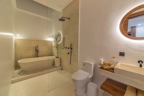 Uma casa de banho moderna com uma banheira independente, sanita e lavatório.