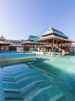 Piscina com degraus azulejados e estrutura de pavilhão em madeira.