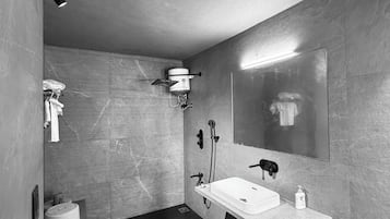 Uma casa de banho moderna com sanita, lavatório e chuveiro.