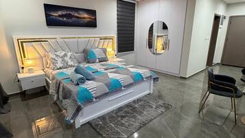 Quarto moderno com cama, mesas de cabeceira, um tapete e espelho fixado na parede.