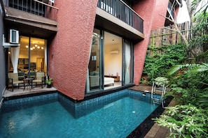 Um imóvel residencial com piscina, varanda e vista para um jardim exuberante.