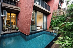 Um imóvel residencial com piscina, varanda e vista para um jardim exuberante.