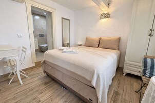 Um quarto com cama, mesa de cabeceira e guarda-roupa.