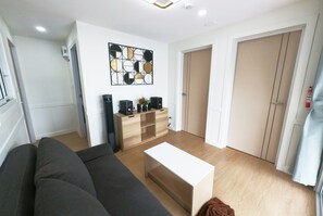 Uma sala de estar moderna com um sofá, uma mesa de centro e um sistema de som embutido na parede.