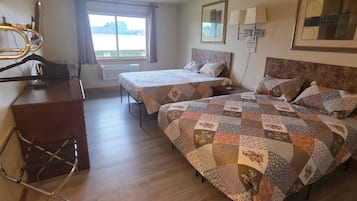 Quarto de hotel com duas camas, uma mesa e uma cadeira.