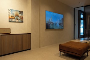 Quarto moderno com cama, radiador e duas pinturas na parede.